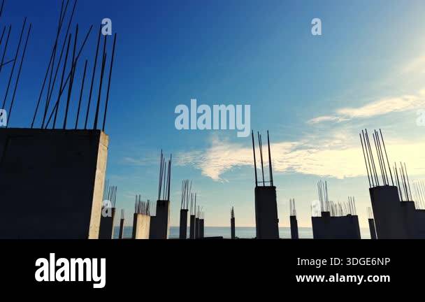 Vertical concrete pillars with protruding rebar and ocean horizon in ...