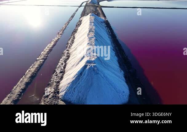 Aerial view focusing on a white salt ridge separating two vivid water ...
