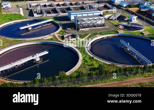 Large sedimentation tanks with mechanical skimmers surrounded by paved ...