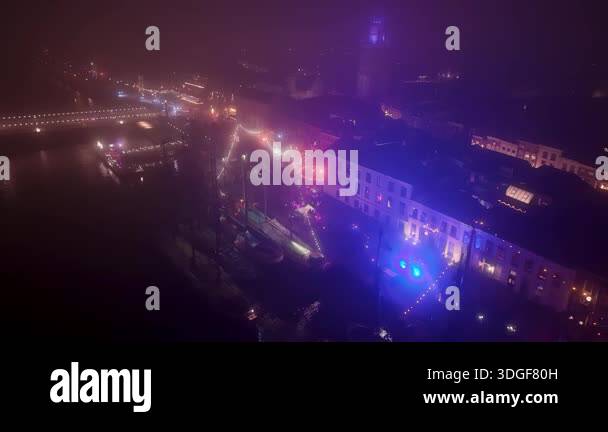 Festive waterfront glows with colorful lights and reflections as ships ...