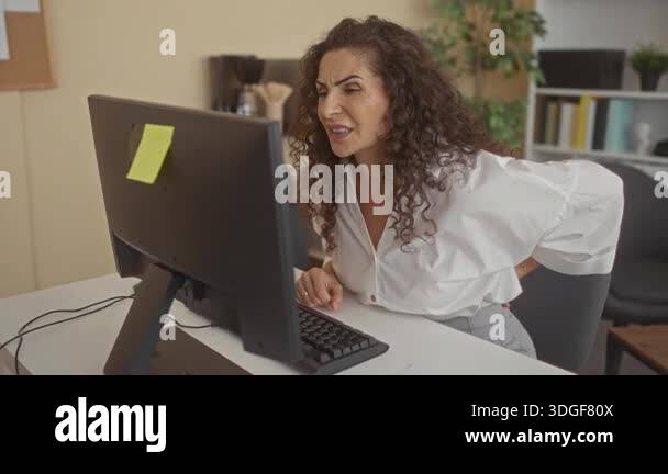 Young hispanic woman holding lower back with backache at office ...
