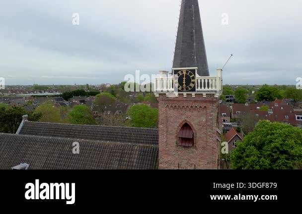 Elevated view of a brick clock tower with pointed slate roof and gold ...