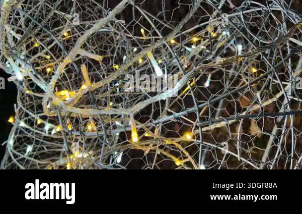 Twinkling garlands on a wire mesh create a festive mood. A close-up of ...