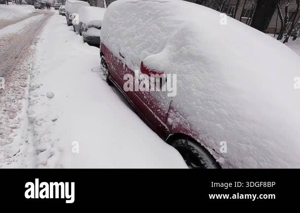 Cars covered in deep snow after a winter blizzard. Vehicles stuck on a ...