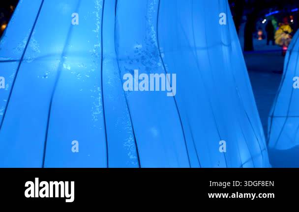 Illuminated futuristic structures in a winter park. Abstract blue light ...