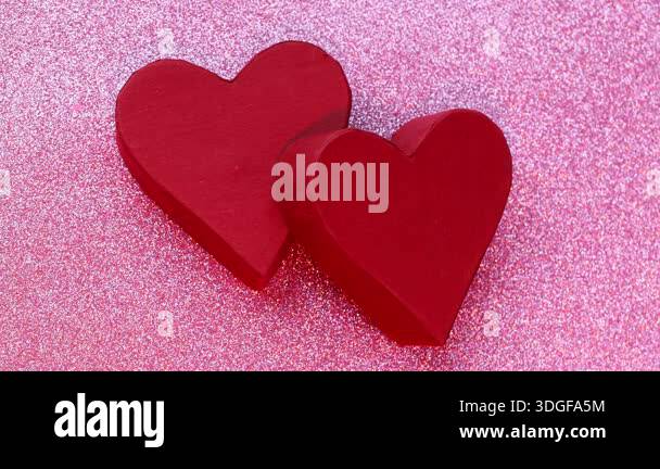 Two Valentine's hearts, a symbol of love, Shiny pink background ...