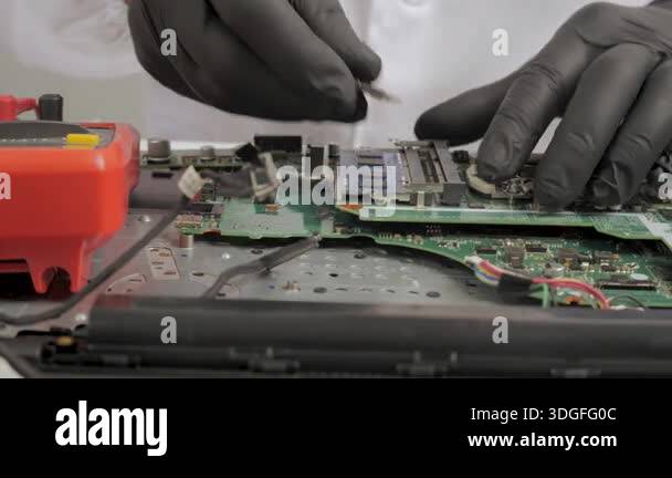 Technician installing memory module on laptop motherboard during ...
