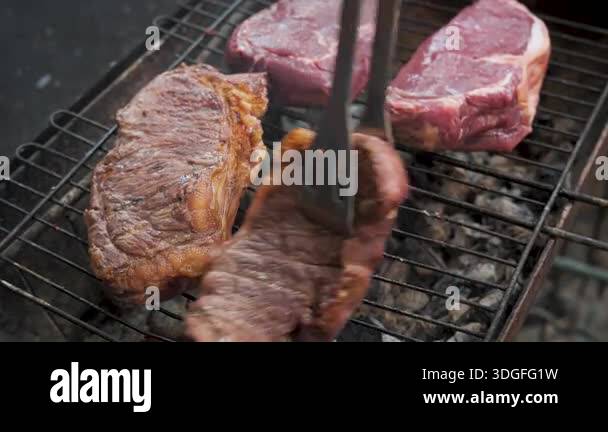Grilling Juicy Beef Steaks Over Charcoal Fire, Close-up of hand ...