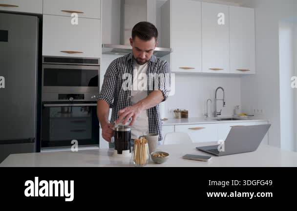 Man preparing coffee with a French press in a bright kitchen Stock ...