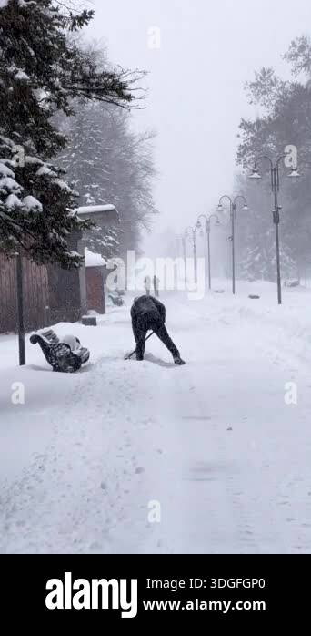 Man Shoveling Deep Snow on a City Park Path During a Heavy Blizzard ...