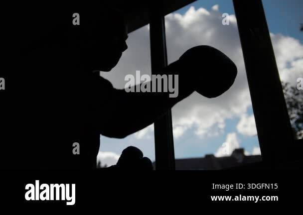 Man boxer is training fighting exercises in front of the window, close ...