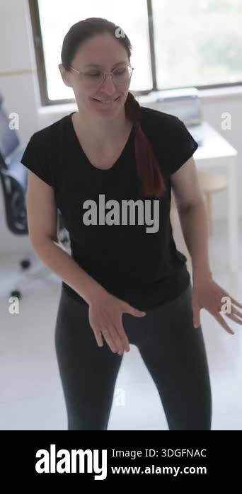 Energetic woman enjoying a home workout, dancing freely in her kitchen ...