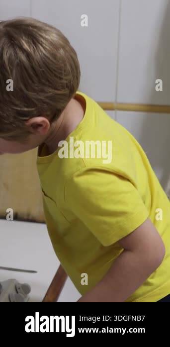 Child playing chef, adding ingredients and stirring a pot on the stove ...