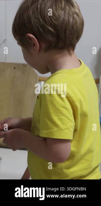 Young boy carefully pouring ingredient into pot on kitchen stove Stock ...