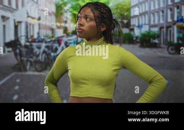 Woman with exposed midriff standing hands on hips and pointing finger ...