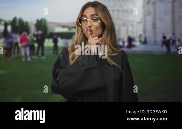 Woman wearing judge robe and glasses with finger to lips for silence in ...