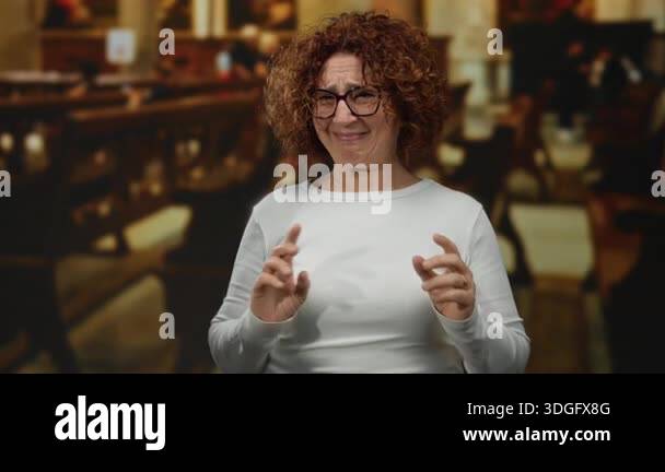 Woman in church gesturing rejection with fingers, mid-age, brunette ...