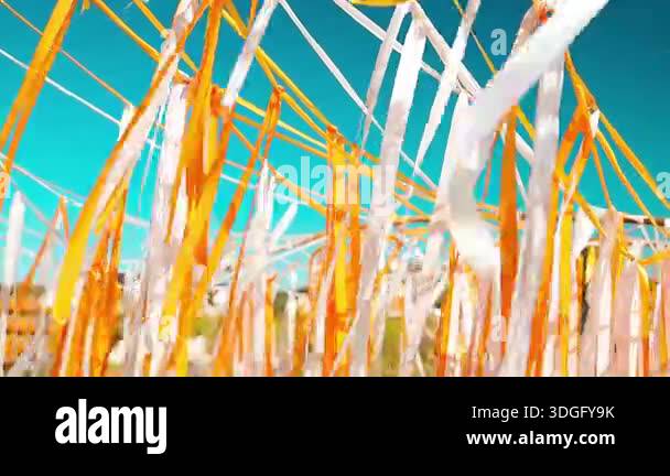 Close-up of orange and white ribbons fluttering in the wind against ...
