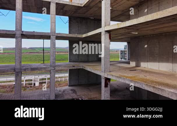 An aerial view of an unfinished concrete building reveals empty floors ...