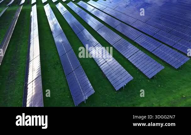Aerial view of solar panels positioned in straight lines on a grassy ...