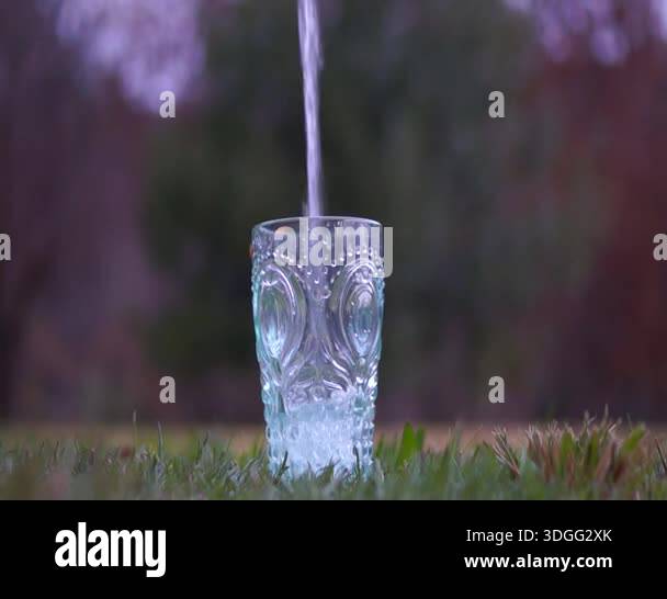 Water pours into a glass until it overflows, symbolizing the waste of ...