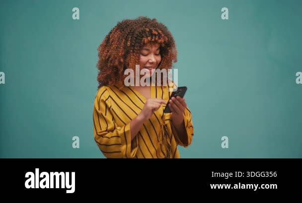 Pretty young woman wearing yellow t-shirt smiles warmly on blue ...