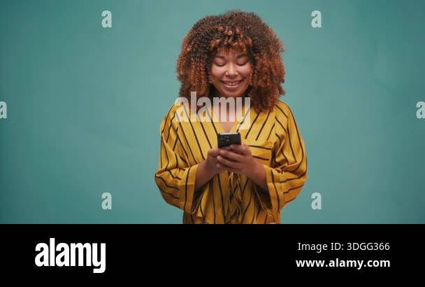 Hispanic woman smiles warmly as scrolls through feed on smartphone on ...