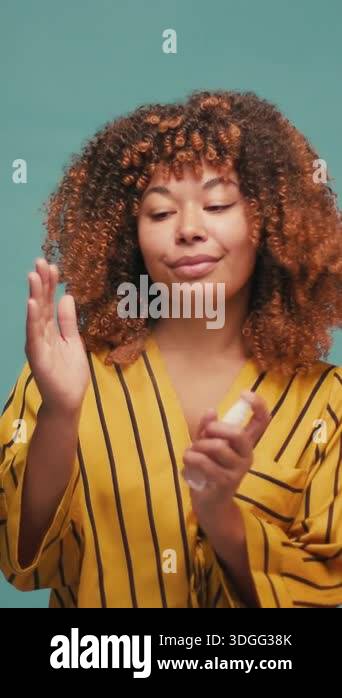 Hispanic latin woman using small portable antibacterial hand sanitizer ...