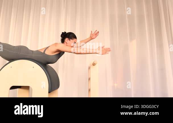 Pilates ladder barrel training machine. Young woman performs Pilates ...