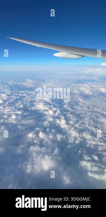 Airplane wing above soft white clouds during flight, aerial view from ...