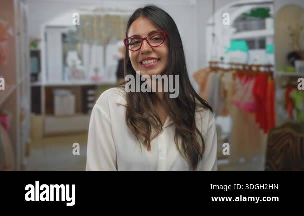Woman smiling inside a stylish retail clothing store with colorful ...