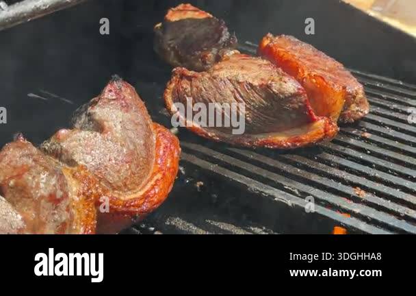 Thick picanha steaks with golden fatcaps sizzle over high heat on ...