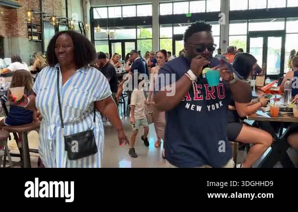 Tampa, Florida, USA - 05.25.2024: Visitors walk and sip colorful ...