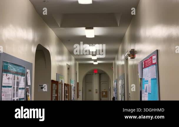 A straight academic hallway displays bulletin boards and posters along ...