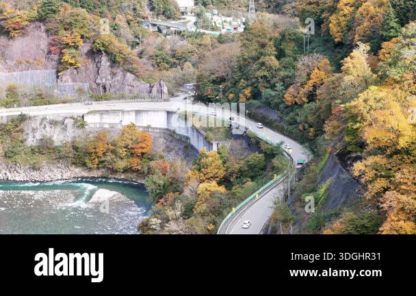 Winding road through colorful autumn trees near river Stock Video ...