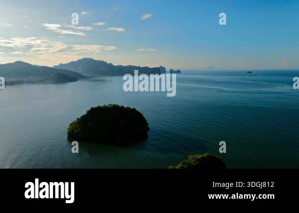 Low Sun Silhouette Island And Tranquil Water With Soft Glow On Horizon ...