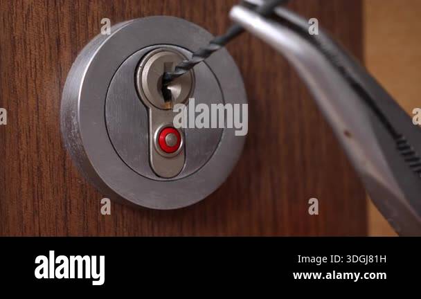 A closeup view shows lock picking tools being used on a modern round ...