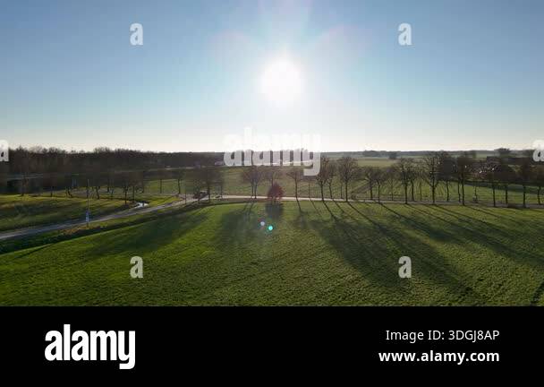 Sunlit Open Field With Long Shadows And Lone Walker On Path, Serene ...