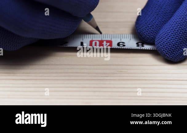Carpenter using tape measure tool in wood workshop. Macro view of metal ...