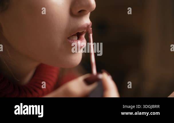 Woman making makeup, close-up. Applying lipstick on lips of young woman ...