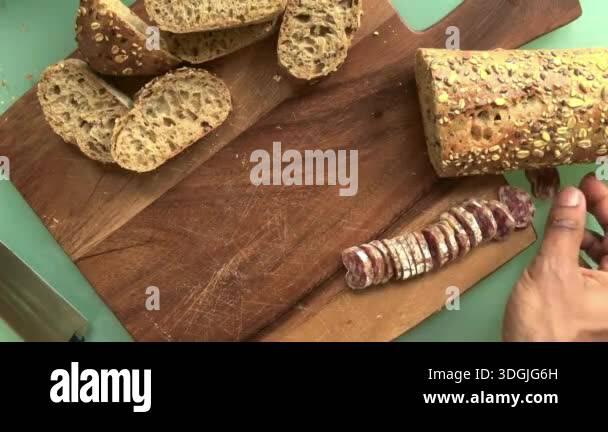 Slices of bread and salami on wooden board Stock Video Footage - Alamy