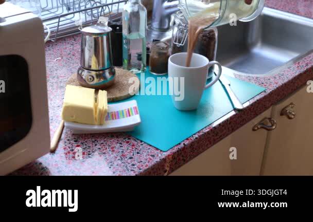 Person making bulletproof coffee with butter at home for breakfast ...