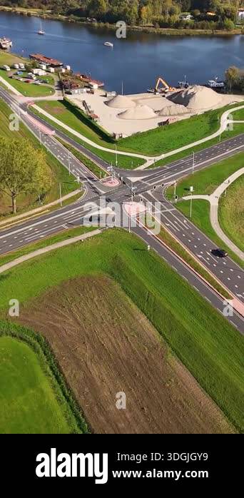 Aerial view of a road intersection with cars driving by and a river ...