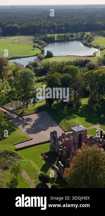 High-angle view of old castle ruins, a park with a lake, and a vast ...