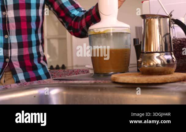 Person making bulletproof coffee with butter at home for breakfast ...