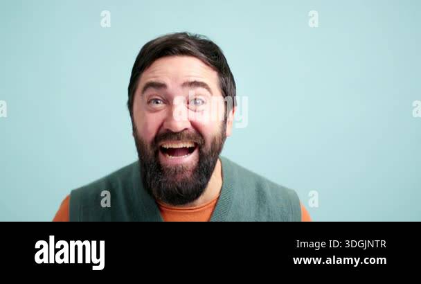 Emotional middle aged bearded man bursting into laughter on a solid ...