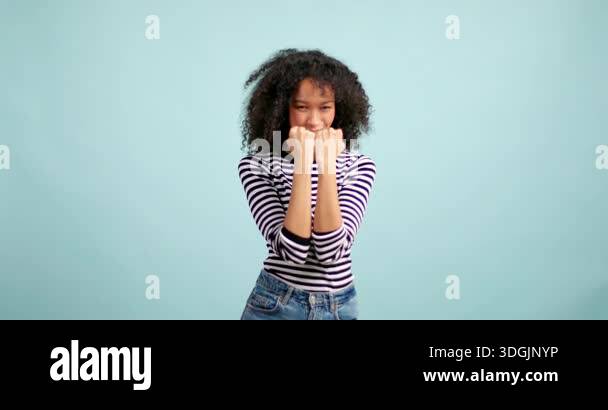 Joyful mixed race woman with curly hair dancing and celebrating her ...