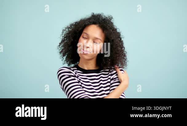 Serene african american woman embracing herself with a peaceful smile ...