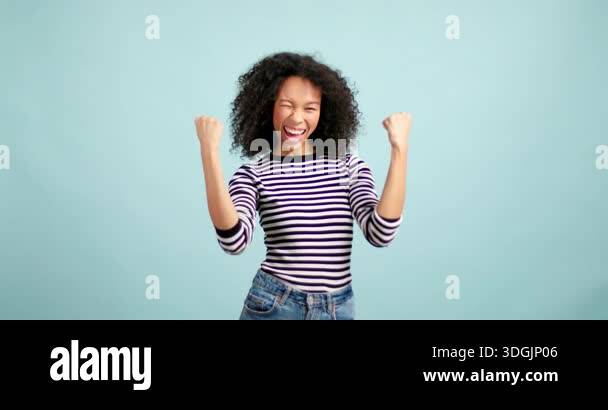 Excited mixed race woman celebrating success, screaming with joy and ...