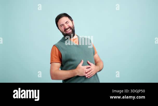 Cheerful man with a beard laughing out loud from a good joke against a ...